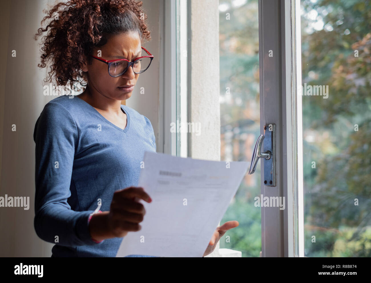Portrait of worried black woman standing beside window Stock Photo - Alamy
