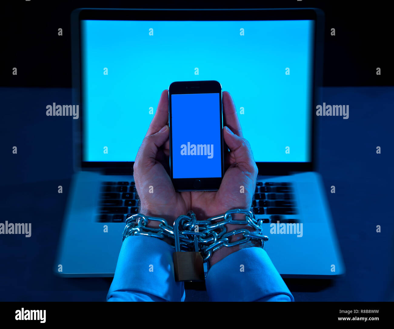 Young man addicted to mobile phone hands bond tied and locked with iron ...