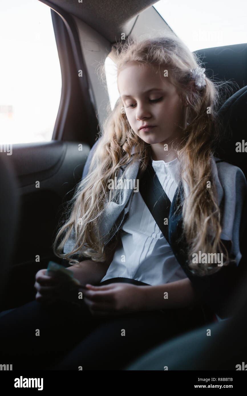 Seven-year charming girl sitting in a children's car seat Stock Photo ...