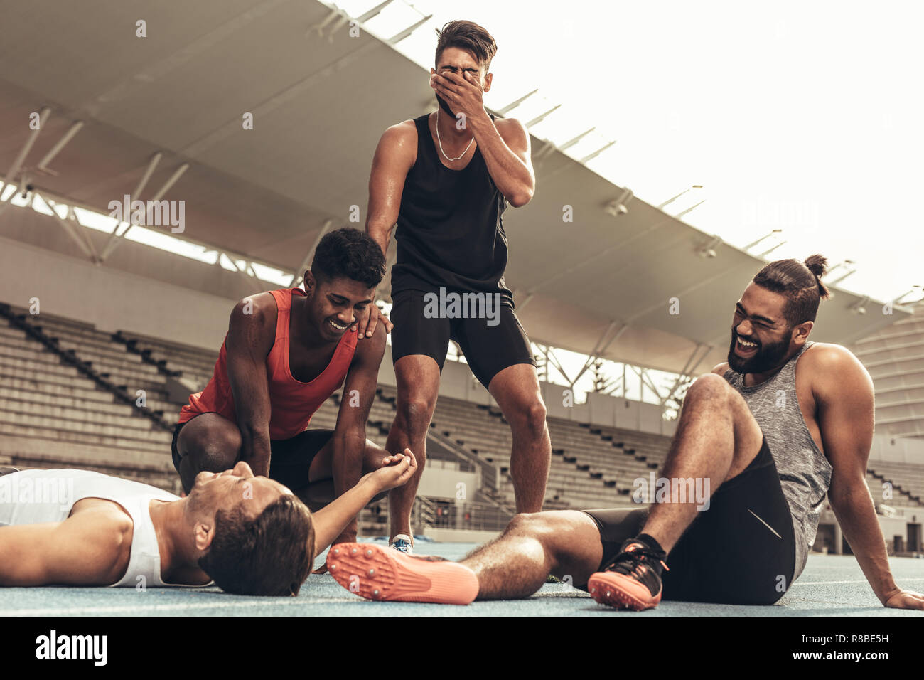 Athletes taking a break after workout sitting on the running track in ...