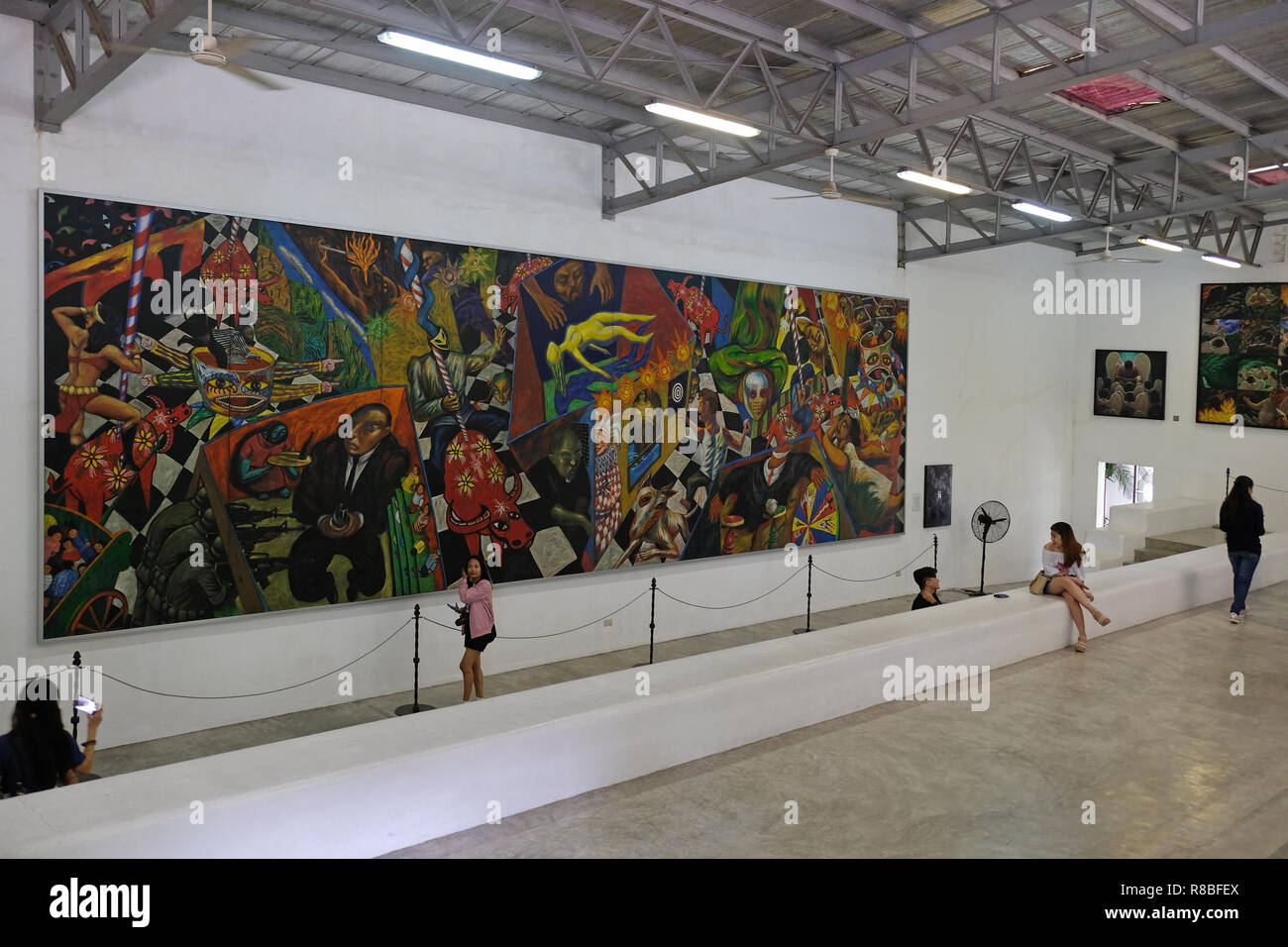 Visitors stand by a contemporary painting entitled “Karnabal” created ...