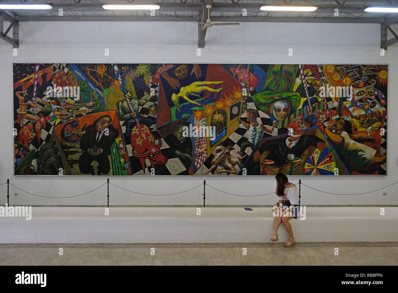 A visitor looking at a contemporary painting entitled “Karnabal ...