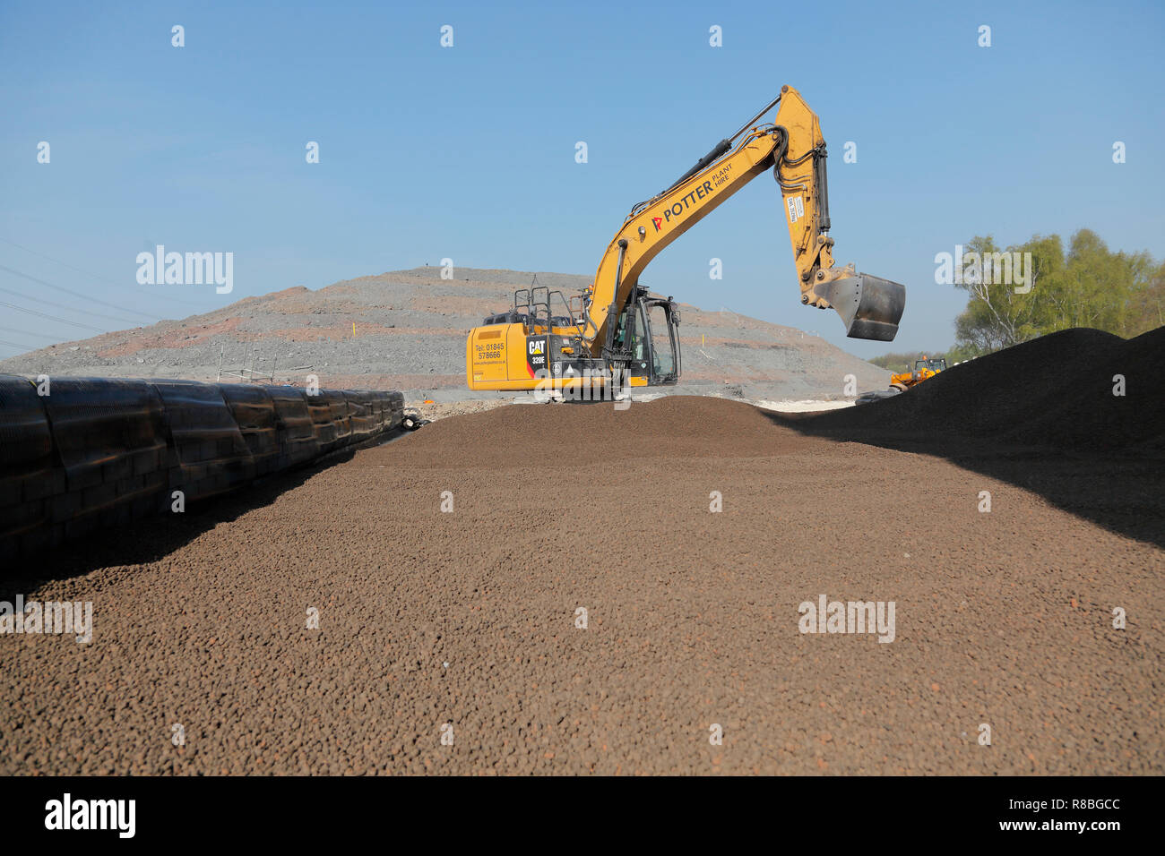 A Caterpillar 320E levelling out lightweight expanded clay aggregate ...