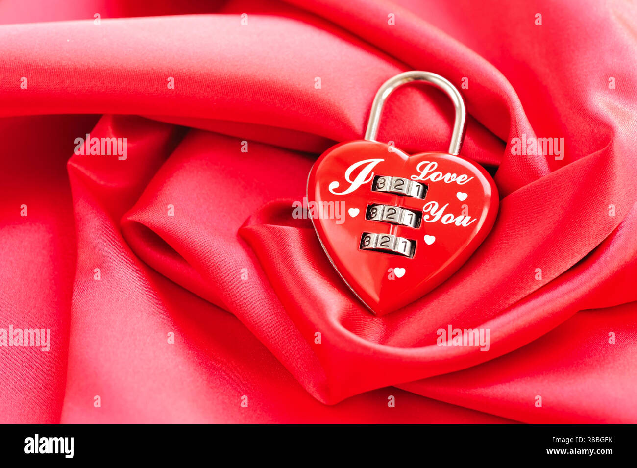 Padlock heart-shape on satin fabric background Stock Photo - Alamy