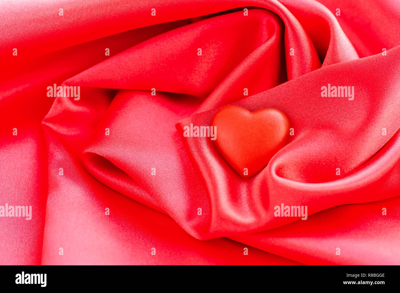 Red heart on satin fabric background Stock Photo - Alamy