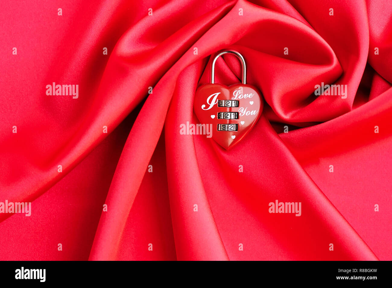 Padlock heart-shape on satin fabric background Stock Photo - Alamy