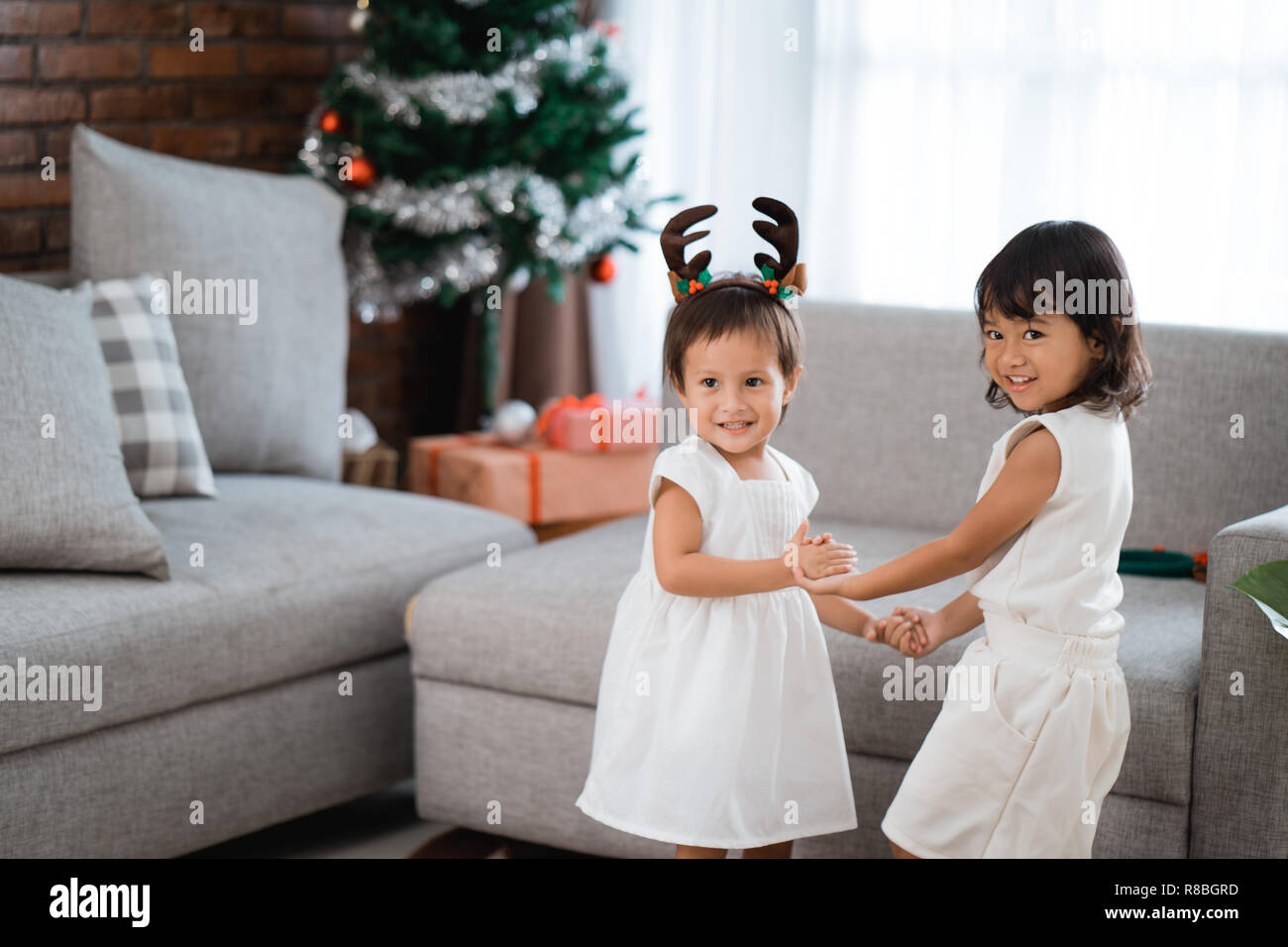 portrait of togetherness two sister playing something and hold hands ...