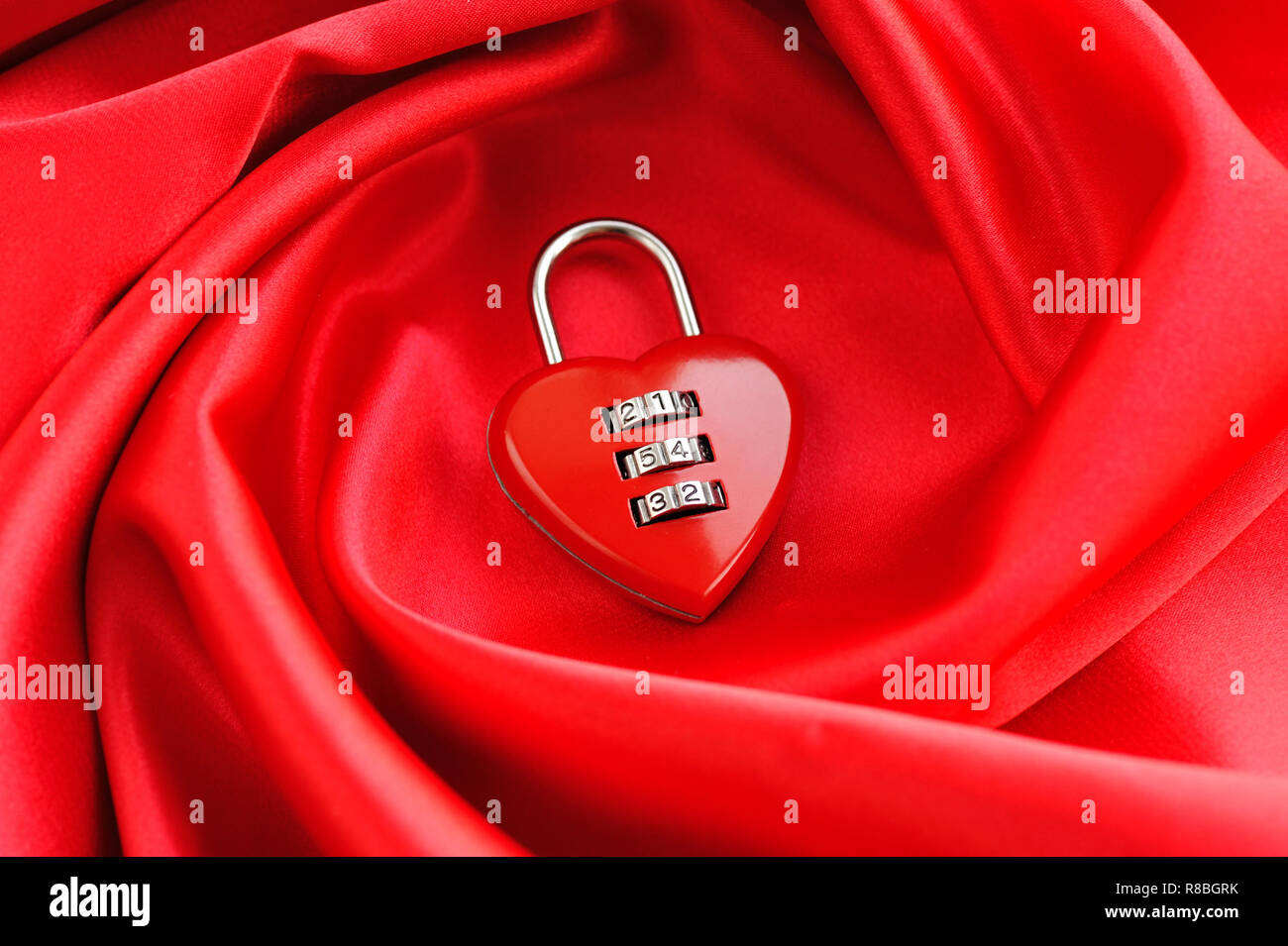 Padlock heart-shape on satin fabric background Stock Photo - Alamy