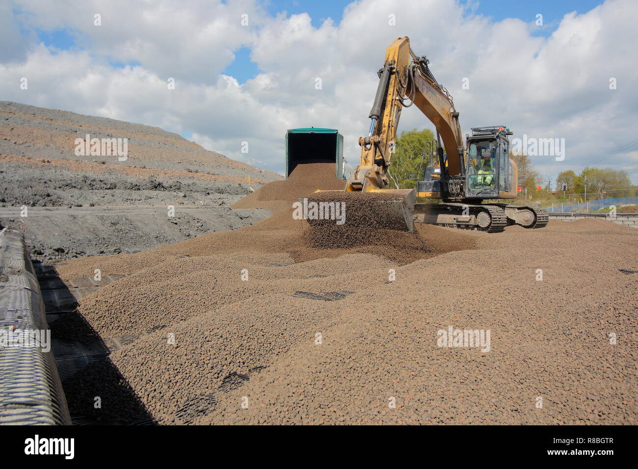 A Caterpillar 320E levelling out lightweight expanded clay aggregate ...