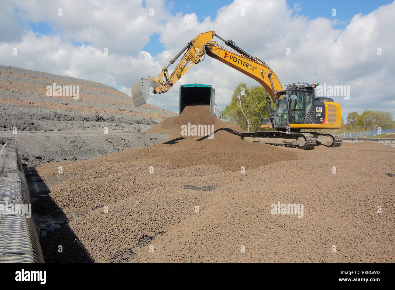A Caterpillar 320E levelling out lightweight expanded clay aggregate ...