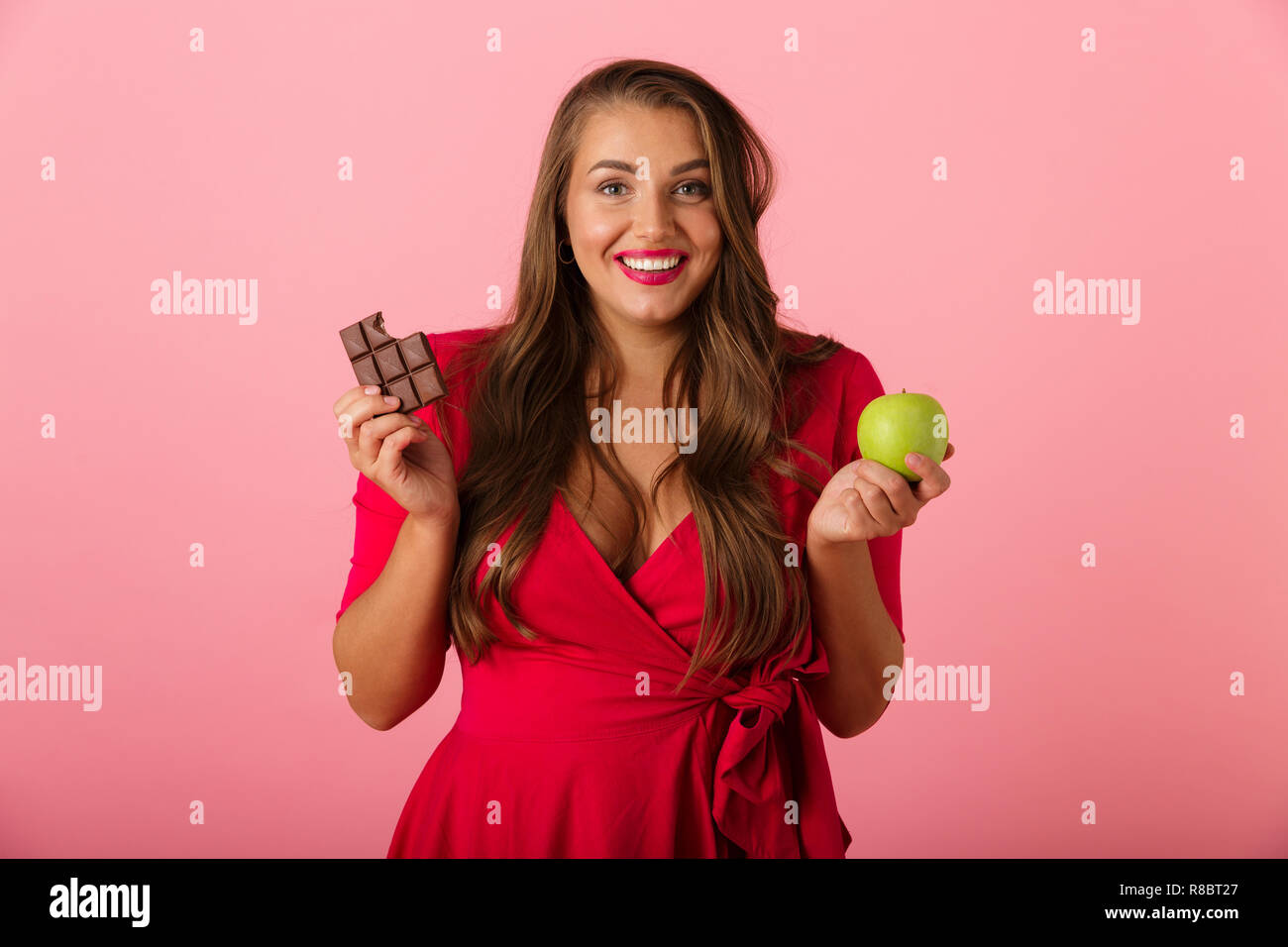 Image of a beautiful hungry young woman isolated over pink wall ...