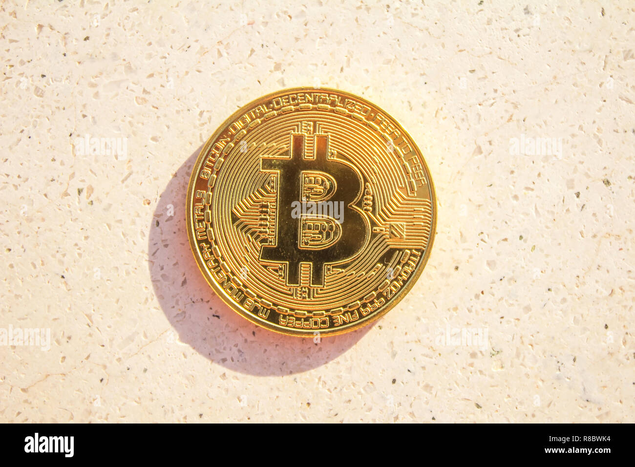 Golden bitcoin coin on white stone background Stock Photo - Alamy