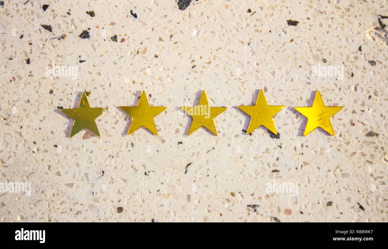 Five yellow stars on white stone background Stock Photo - Alamy