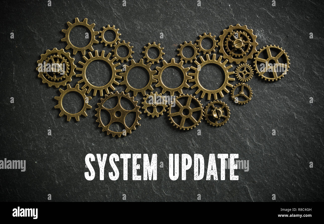 cogwheels and the words "system update" on slate background symbolizing ...
