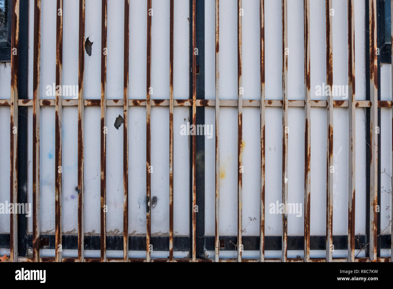 Closed white bars rusty metallic gate detail Stock Photo - Alamy