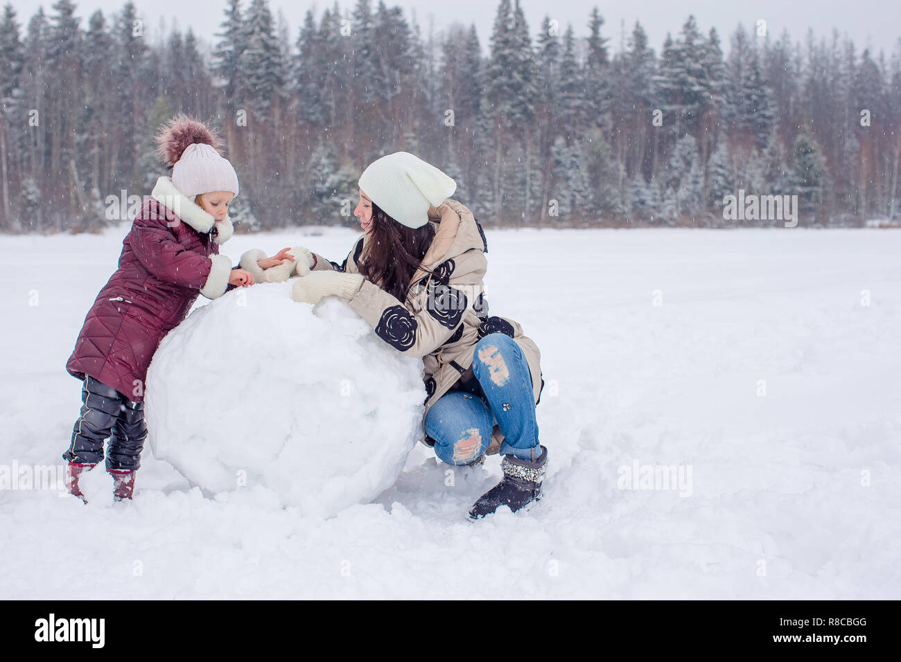 Happy family of mom and kid enjoy winter snowy day Stock Photo - Alamy