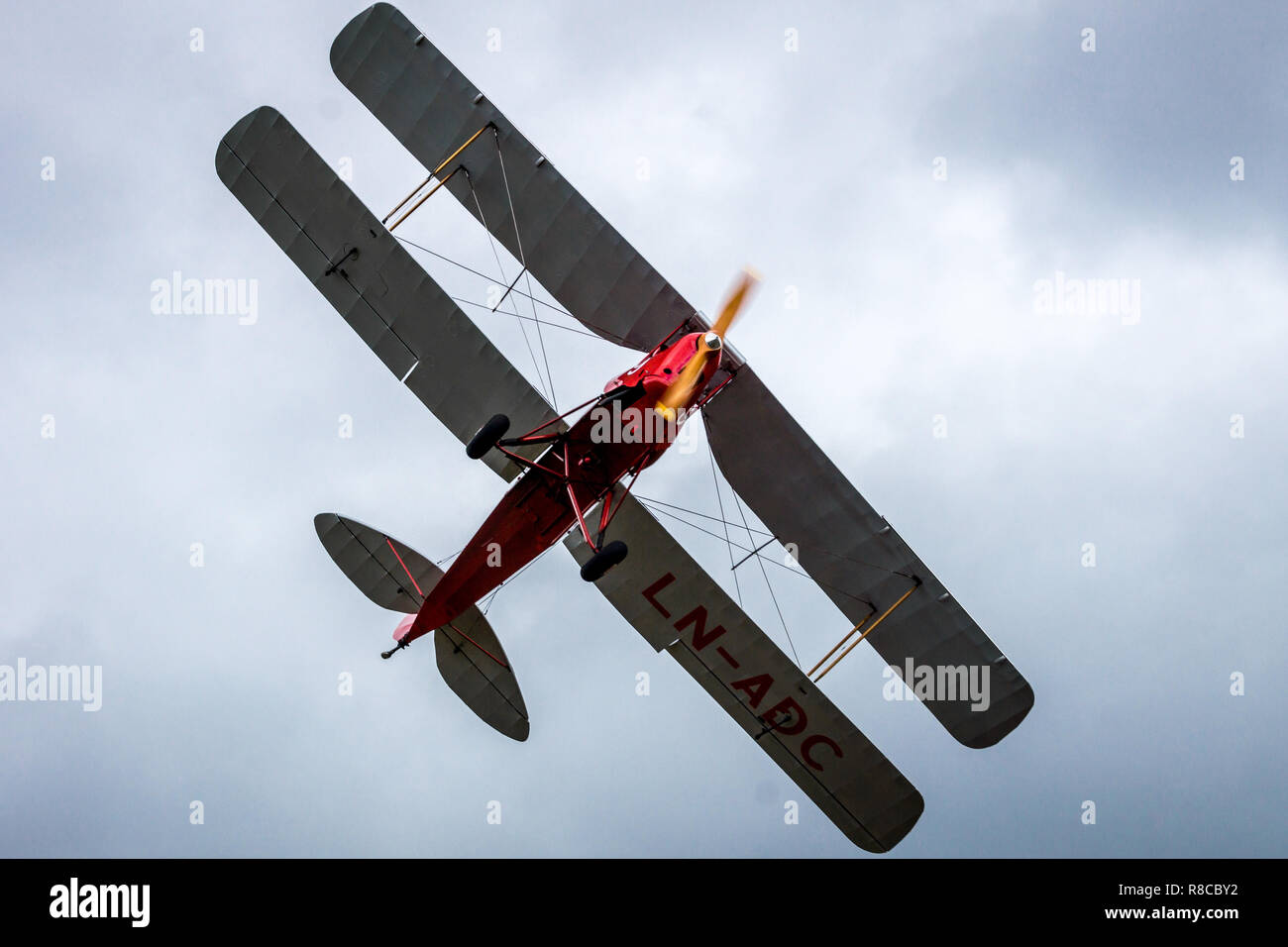 red small propeller plane in motion. shot from underneath. flying ...