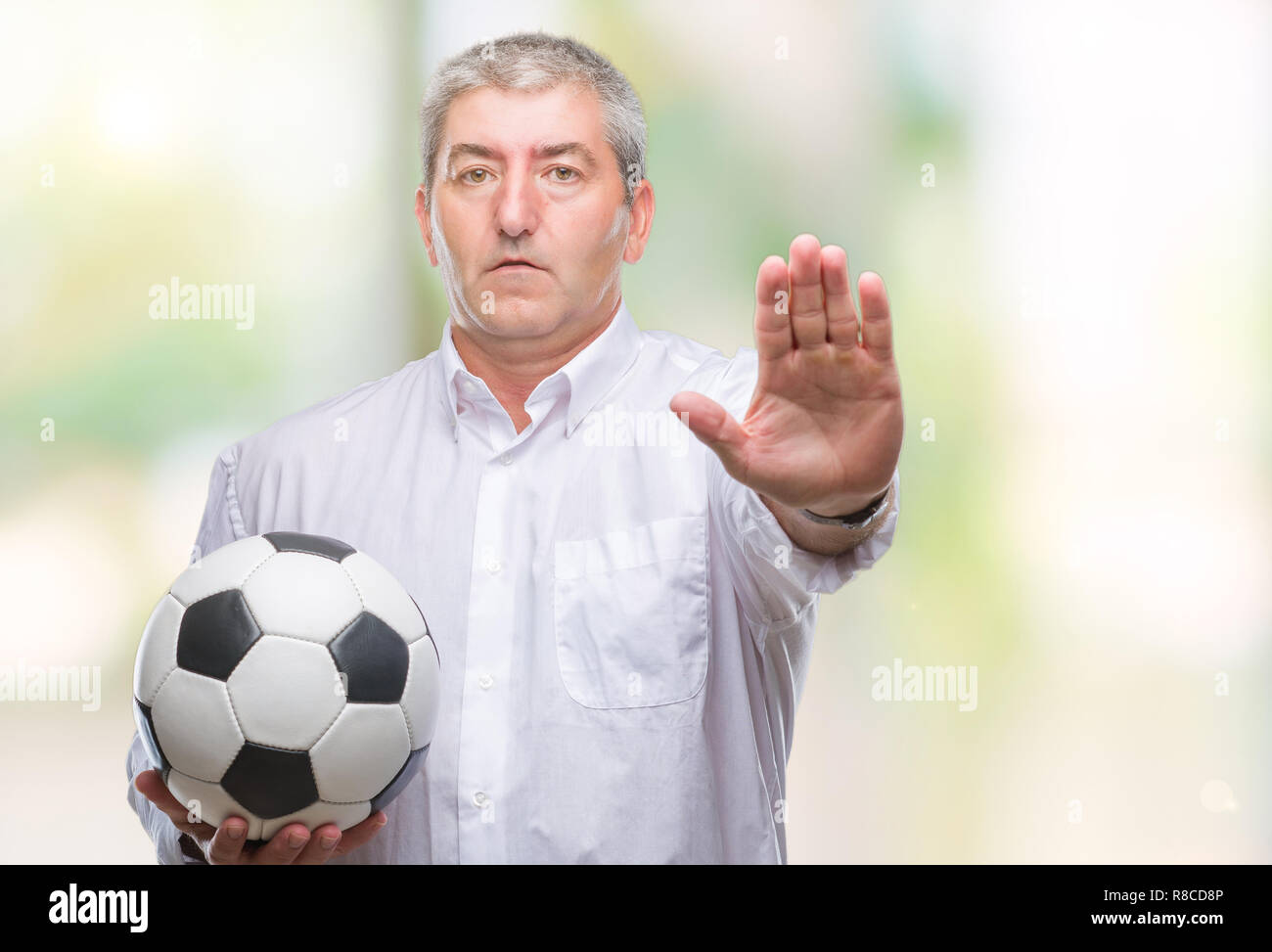 Handsome senior man holding soccer football ball over isolated ...