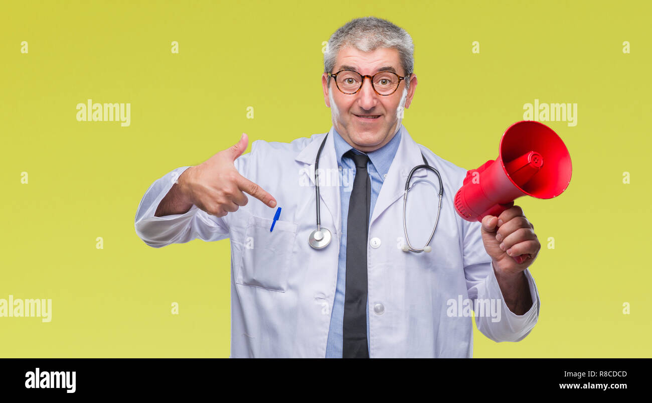 Handsome senior doctor man yelling through megaphone over isolated ...