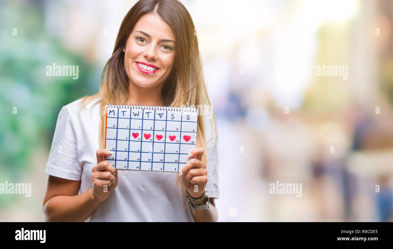 Young beautiful woman holding menstruation calendar over isolated ...