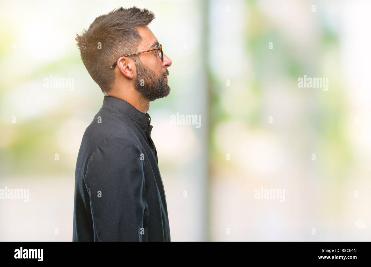 Adult hispanic catholic priest man over isolated background looking to ...