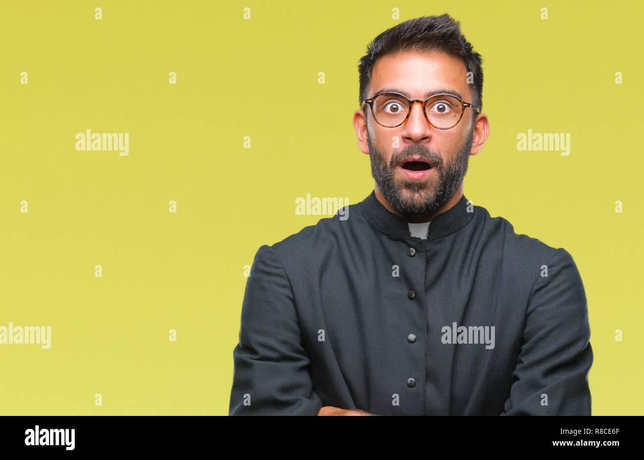 Adult hispanic catholic priest man over isolated background afraid and ...