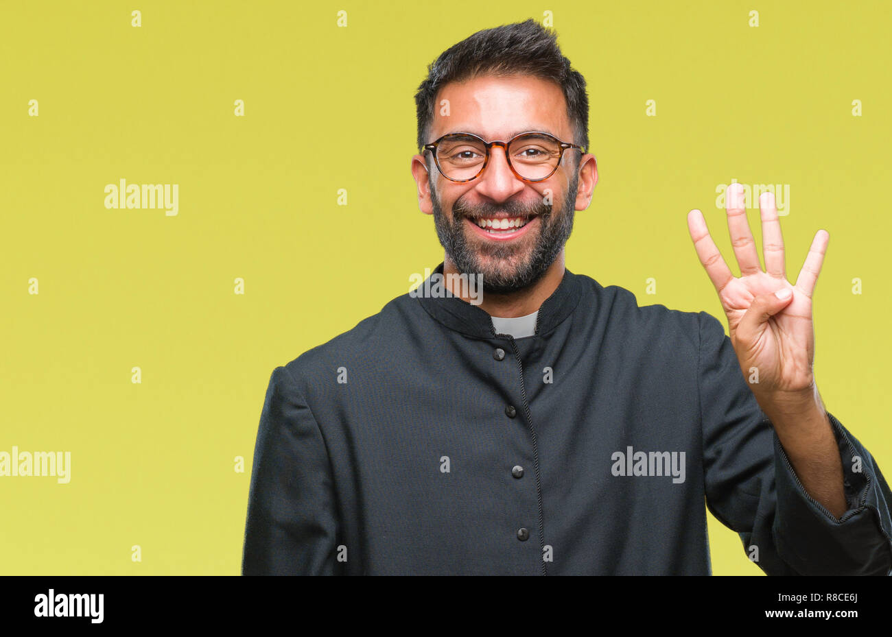Adult hispanic catholic priest man over isolated background showing and ...