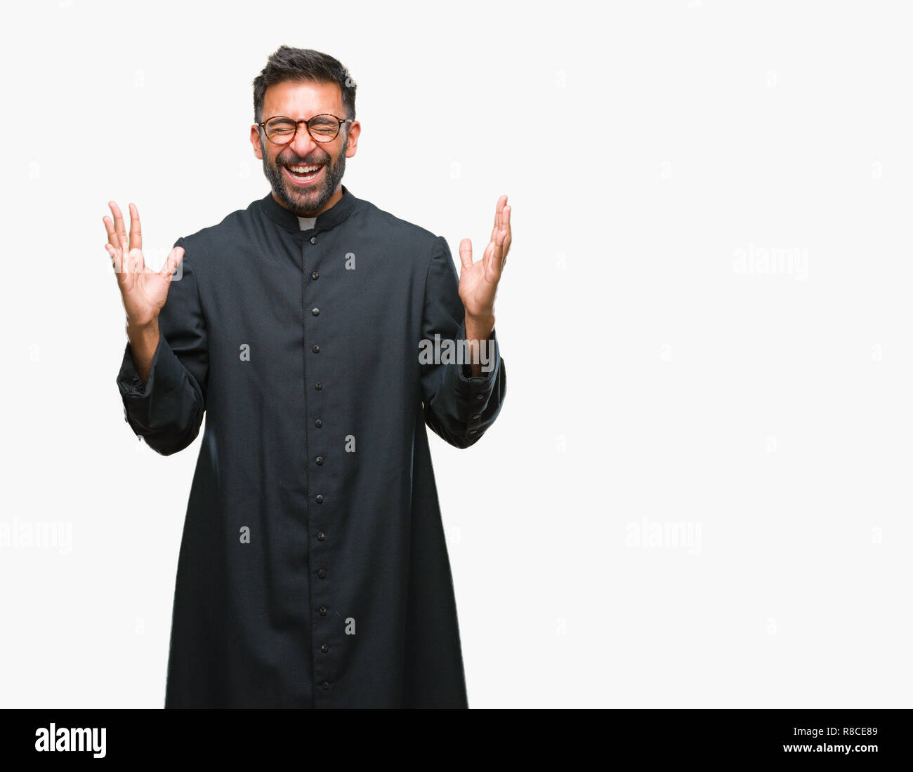 Adult hispanic catholic priest man over isolated background celebrating ...