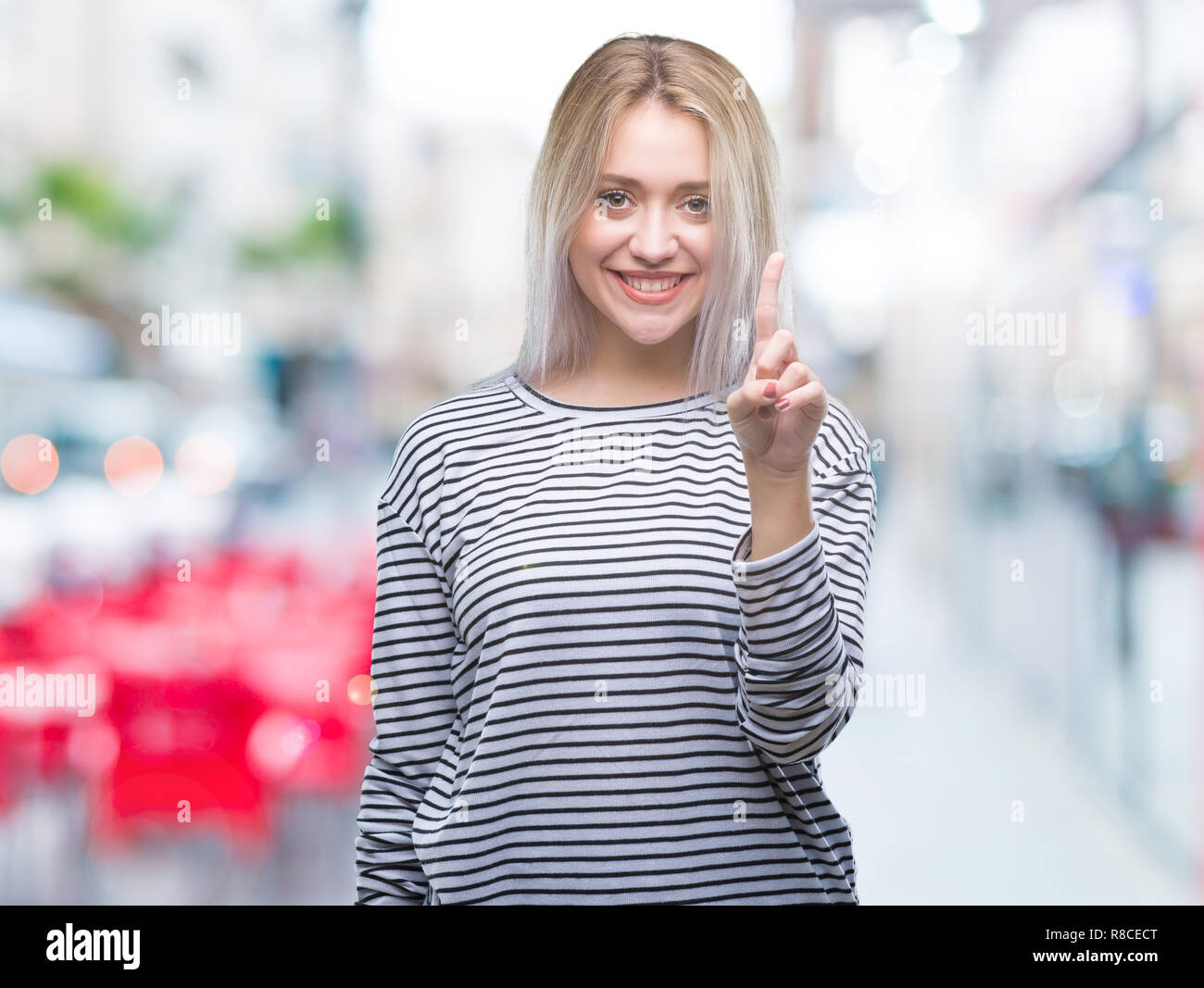 Young blonde woman over isolated background showing and pointing up ...