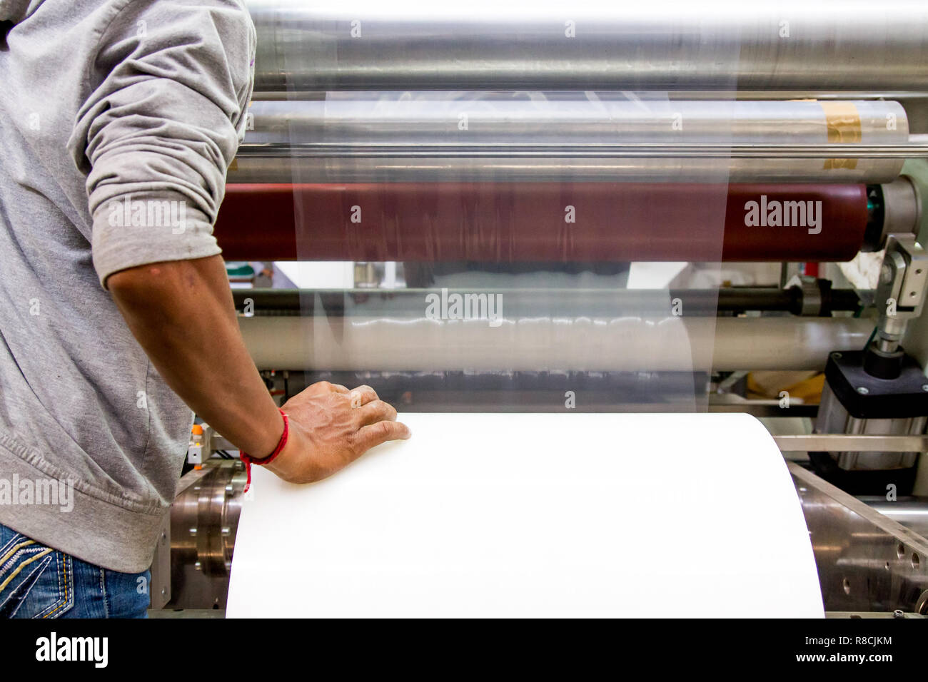 doypack making packaging machine in modern factory with white rolls and ...