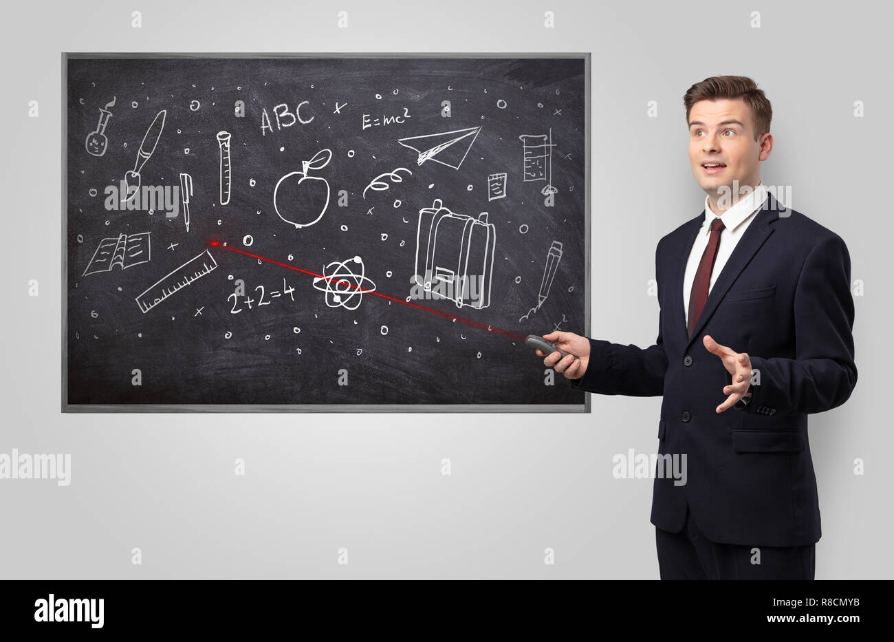 Handsome young teacher with laser pointer teaching Stock Photo - Alamy