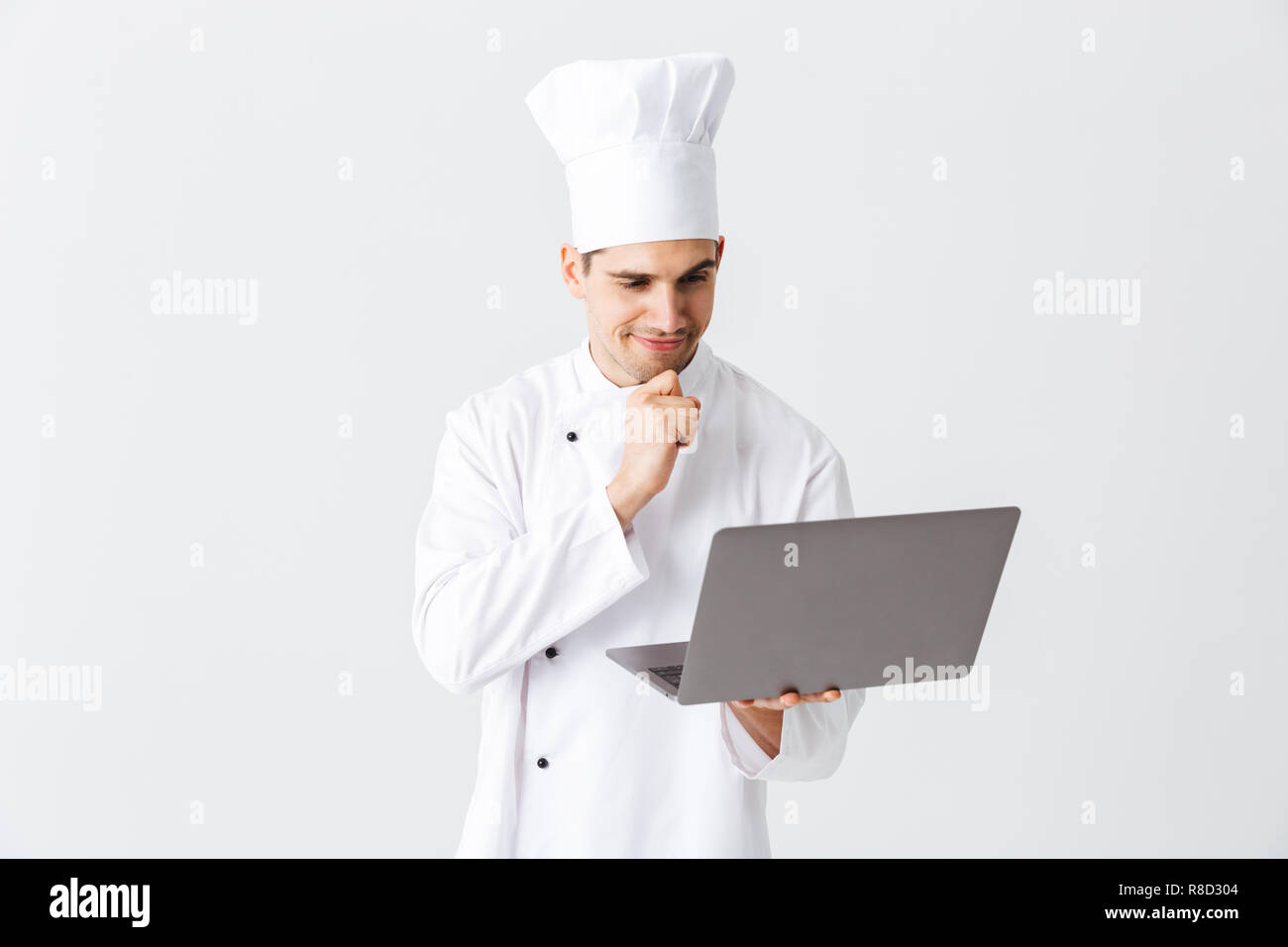 Pensive chef cook wearing uniform standing over white background ...