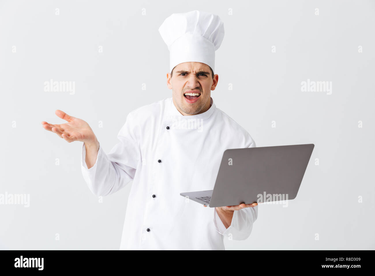 Confused chef cook wearing uniform standing over white background ...