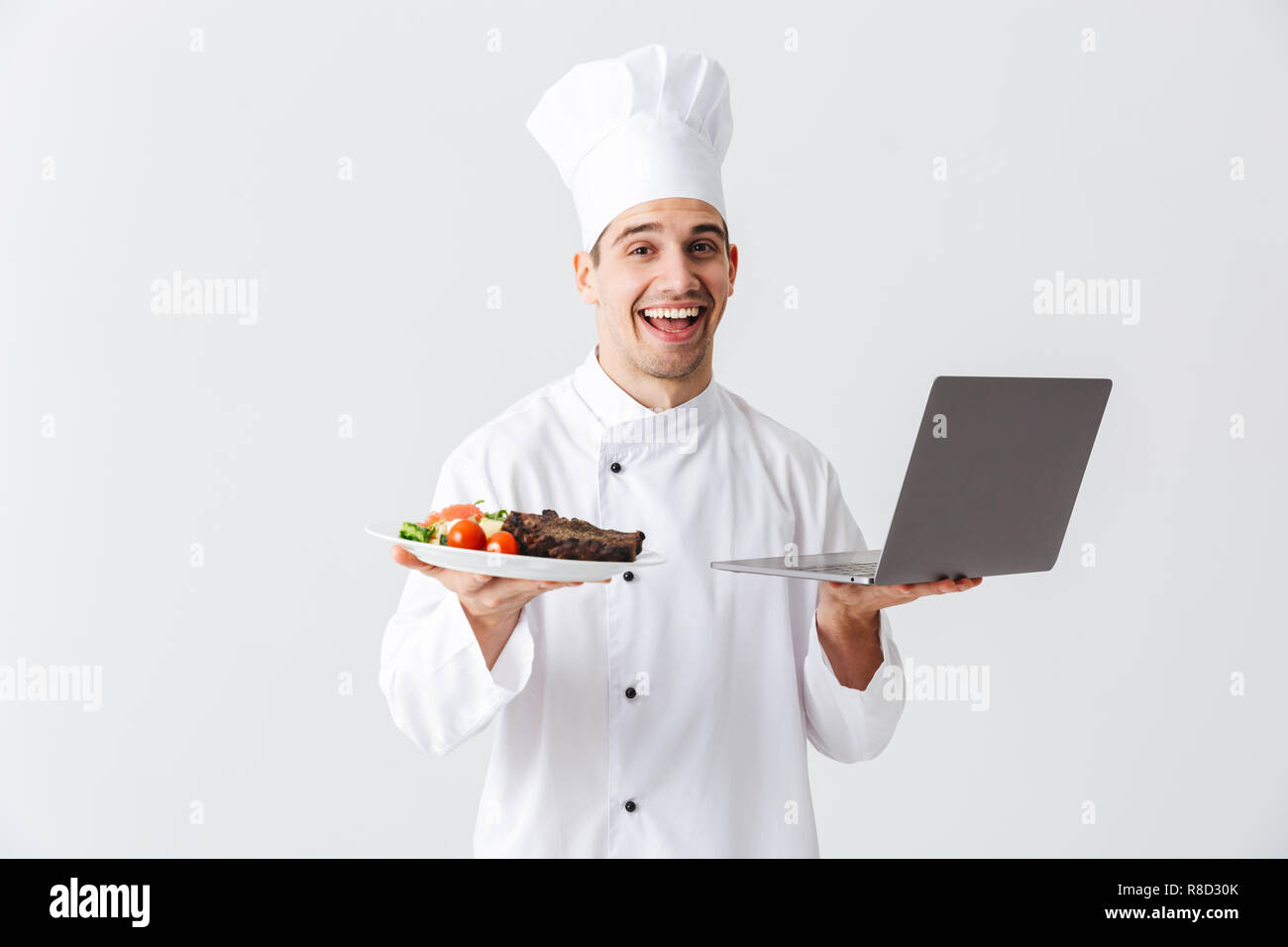Excited chef cook wearing uniform standing over white background ...