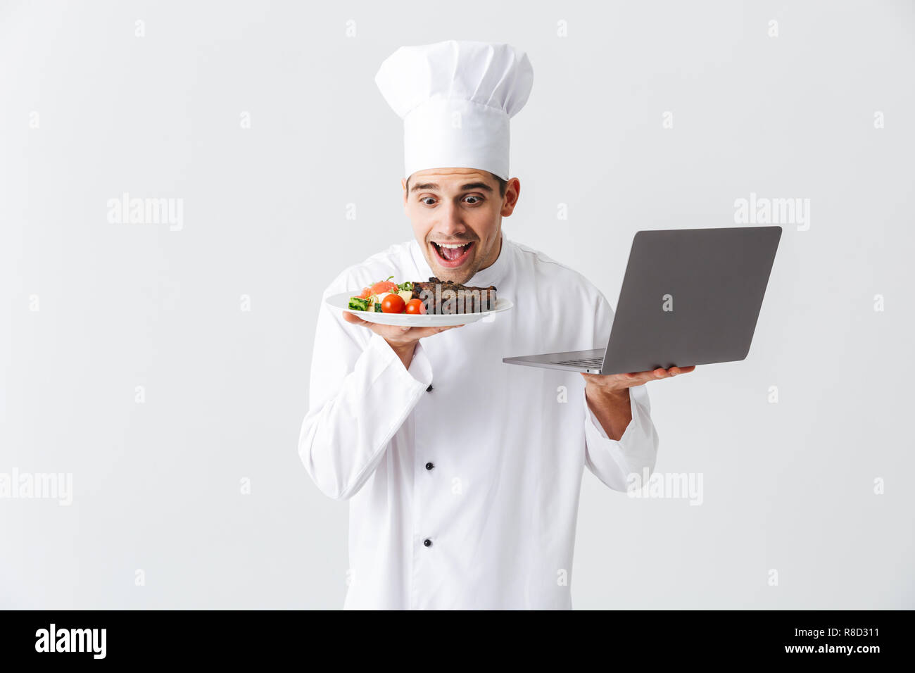 Excited chef cook wearing uniform standing over white background ...