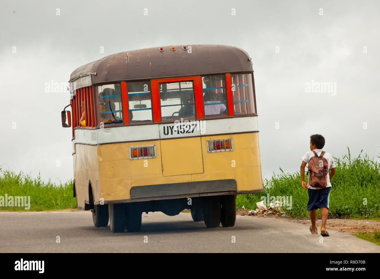 A boy trying to catch a bus in Iquitos,Peru Stock Photo - Alamy