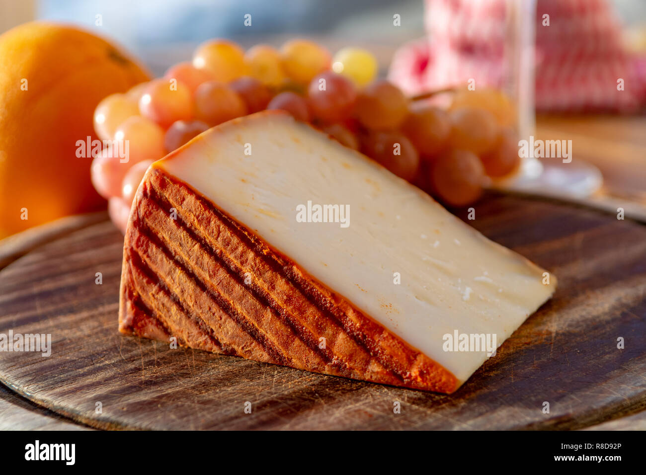 Spanish goat milk cheese with paprika coating and ripe pink table ...