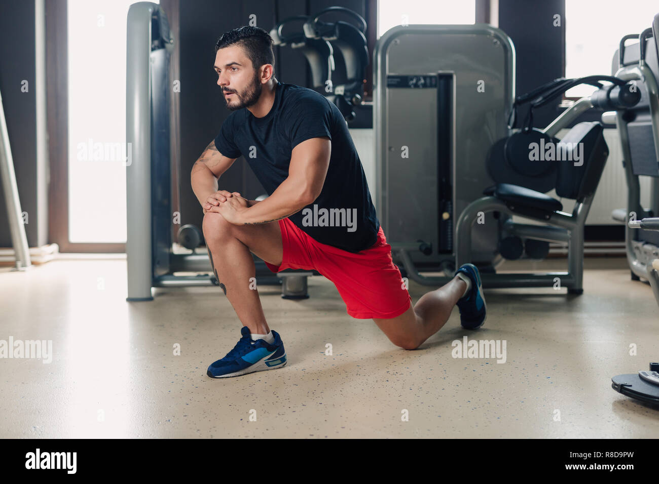 Strong bearded man in the gym stretching Stock Photo - Alamy
