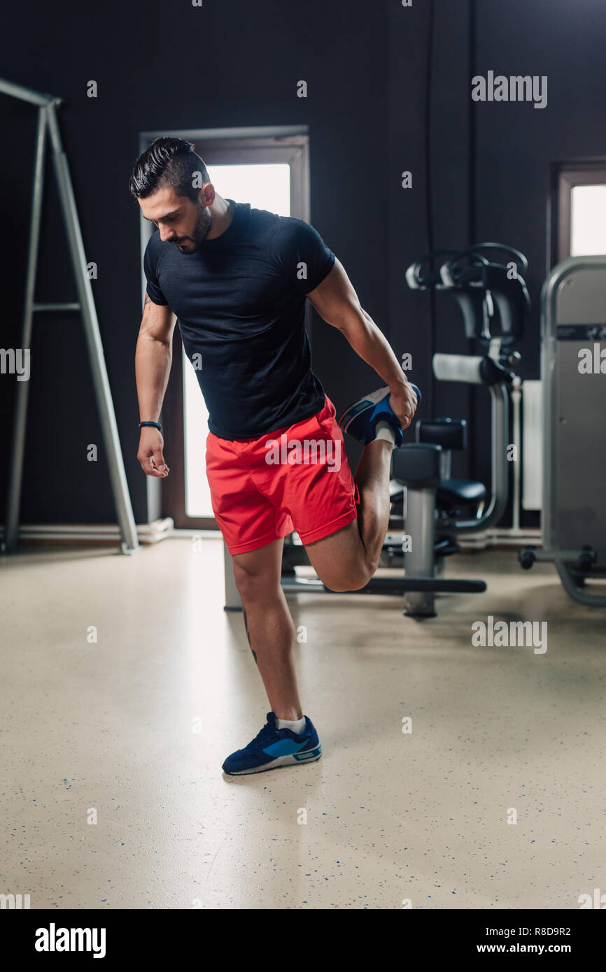 Strong bearded man in the gym stretching Stock Photo - Alamy