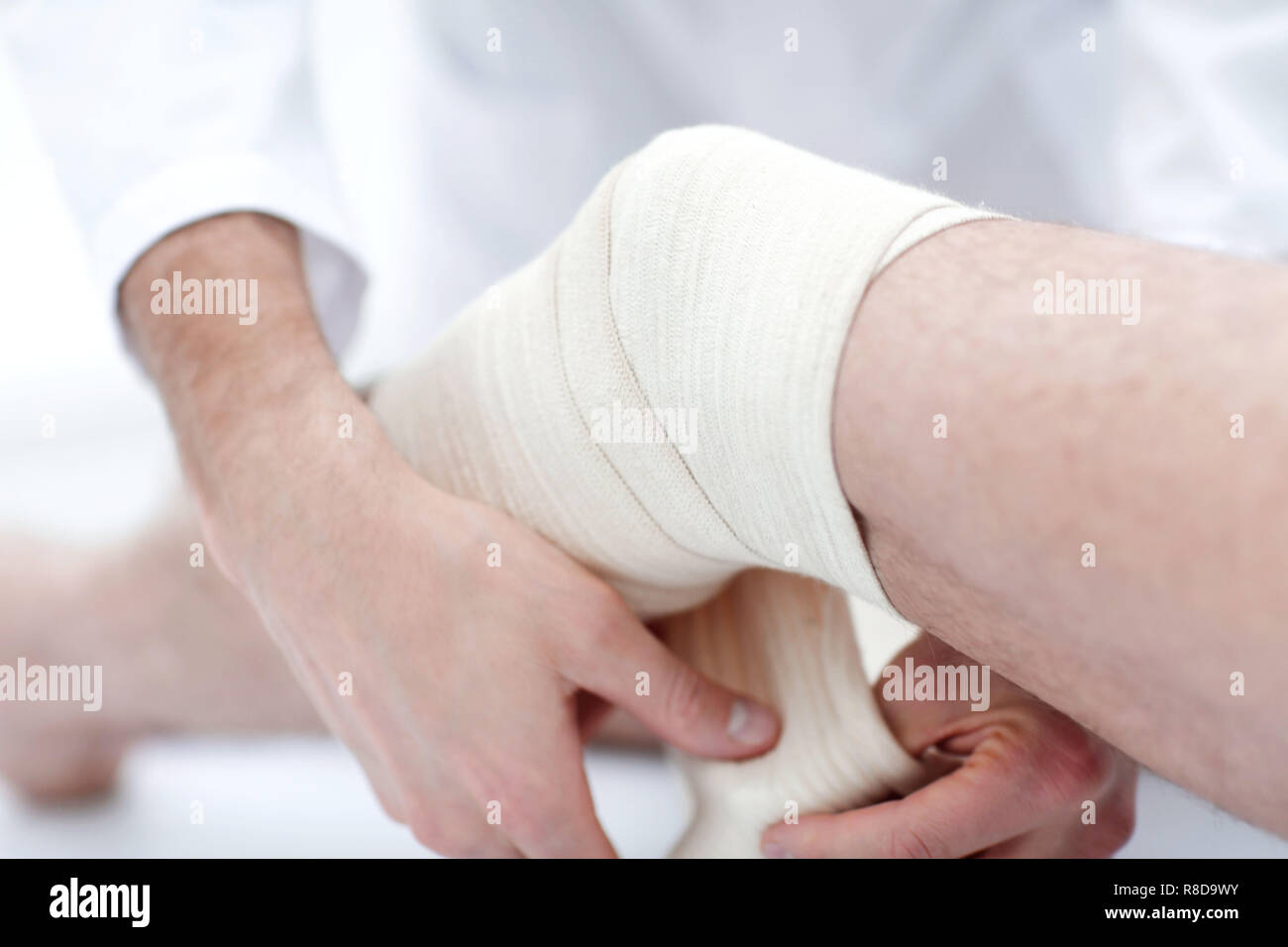 closeup. doctor bandaging a patient's leg Stock Photo - Alamy