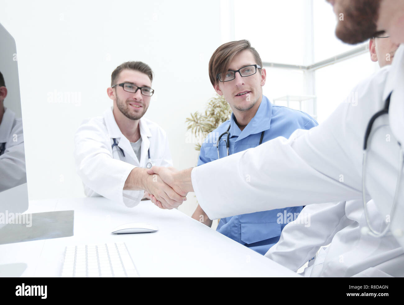 Friendly handshake between colleagues hi-res stock photography and ...