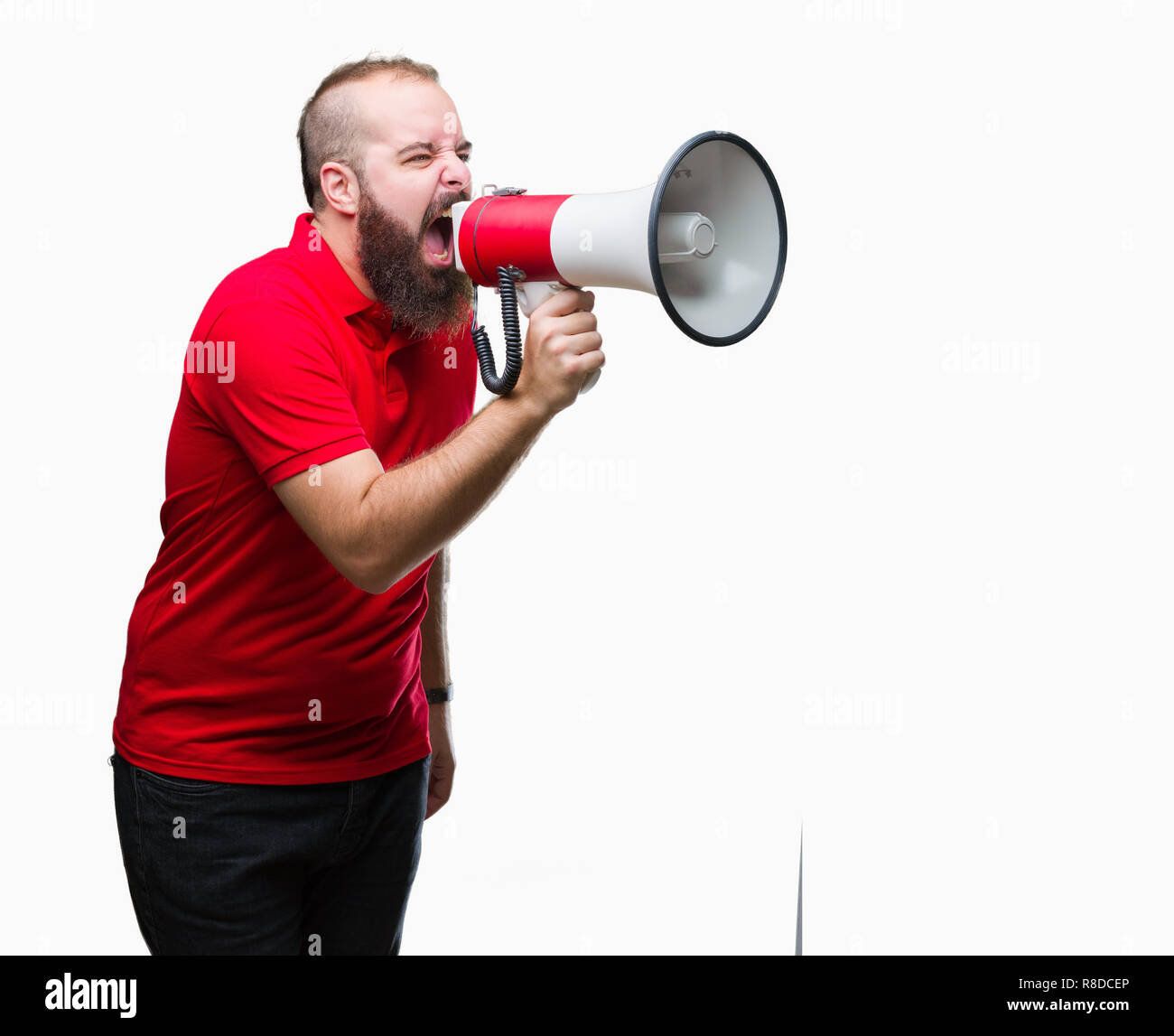 Young caucasian man shouting through megaphone over isolated background ...