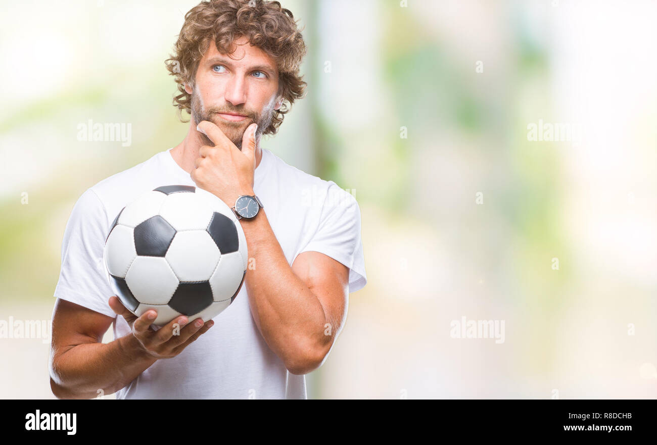 Handsome hispanic man model holding soccer football ball over isolated ...