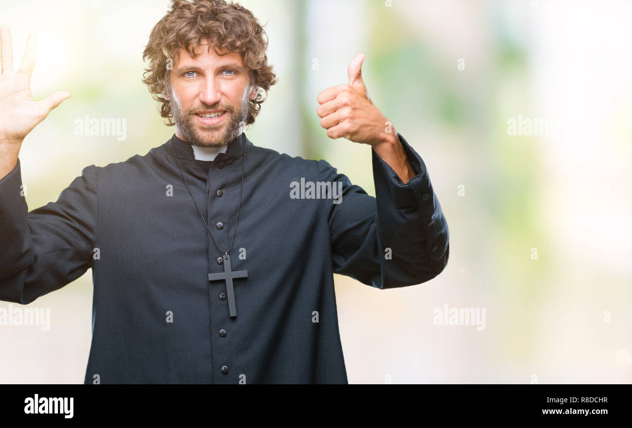 Handsome hispanic catholic priest man over isolated background showing ...