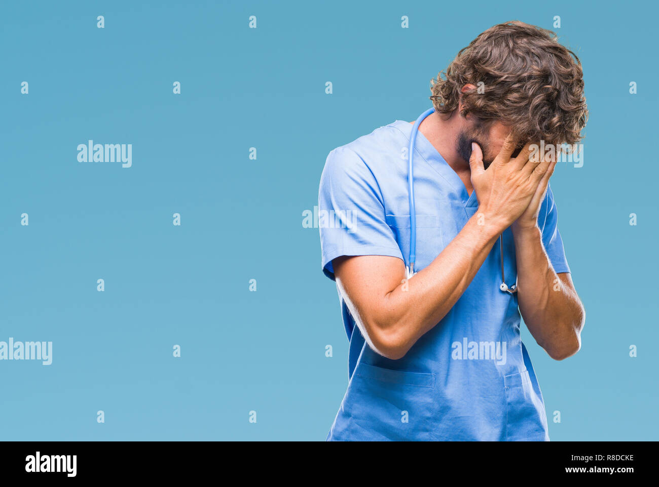 Handsome hispanic surgeon doctor man over isolated background with sad ...