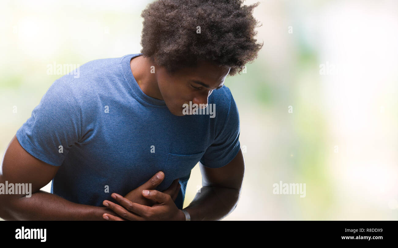 Afro american man over isolated background with hand on stomach because ...