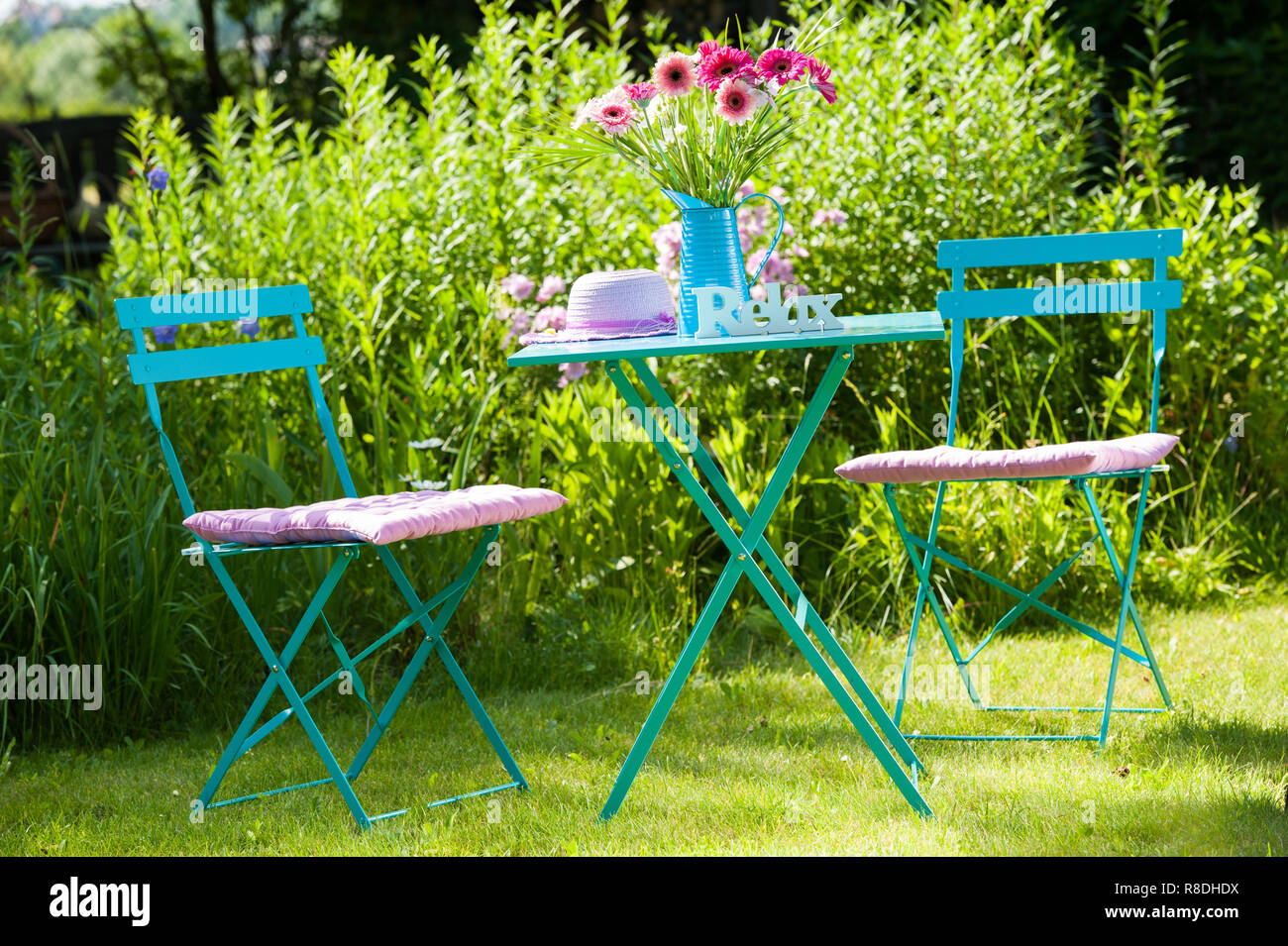 Idyllic garden with table and chair Stock Photo - Alamy