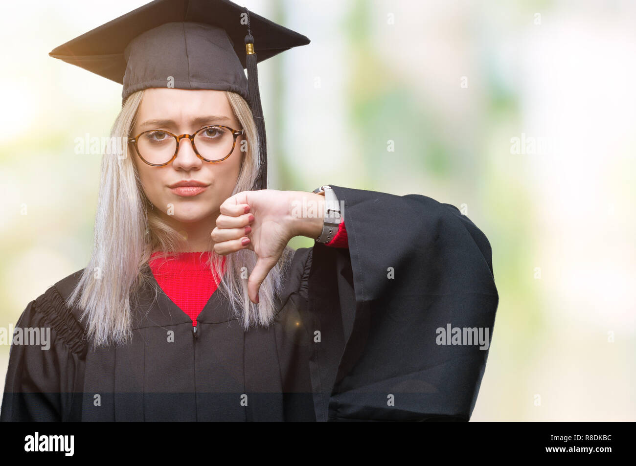 Young blonde woman wearing graduate uniform over isolated background ...