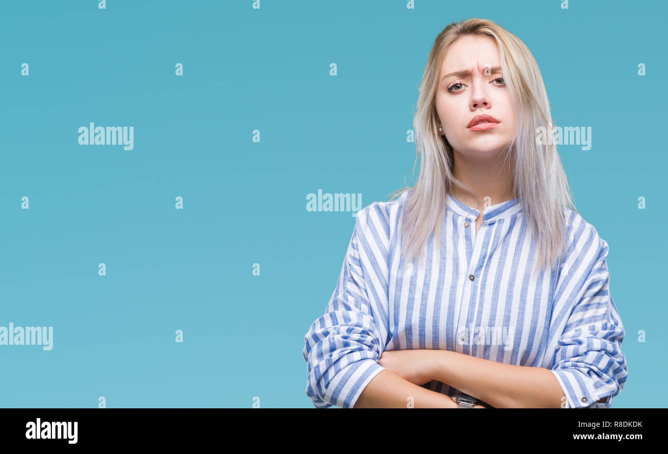 Young blonde woman over isolated background skeptic and nervous ...