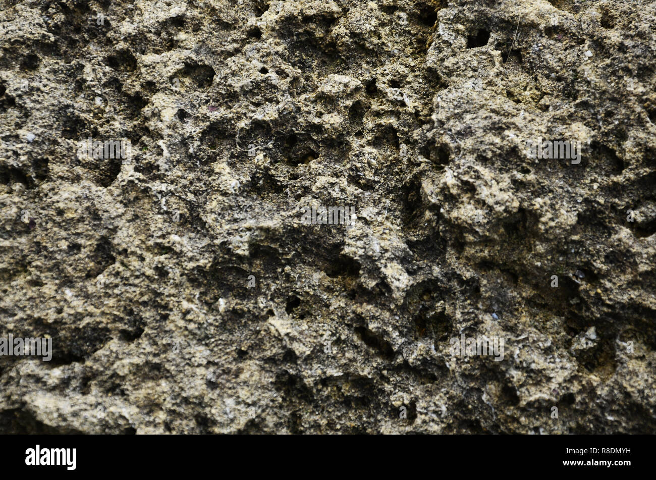 Close up of an old weathered and stained stone wall texture in daytime ...